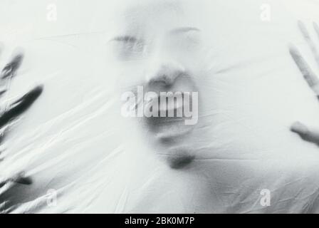 Human face pressing through fabric as horror background Stock Photo - Alamy