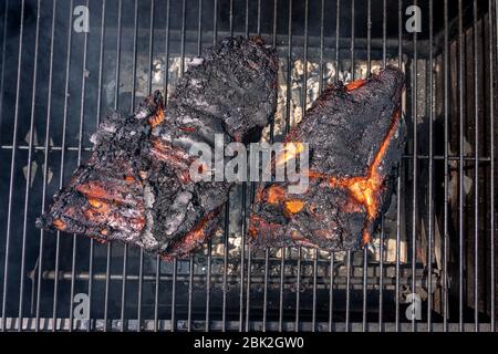 overcooked ruined black bbq ribs on the charcoal grill Stock Photo - Alamy
