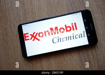 The Exxon Mobil logo displayed on a phone screen against a world map ...
