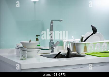 A mountain of dirty dishes in the kitchen sink. Mess in the house Stock ...