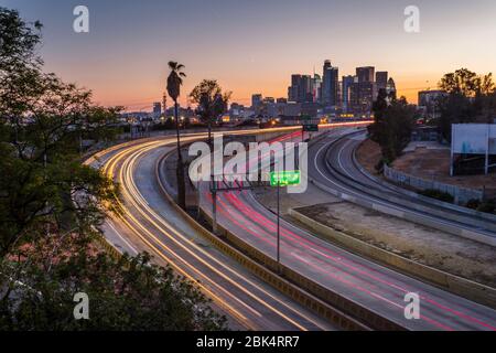 View of Downtown LA and freeway trail lights at sunset, Los Angeles ...