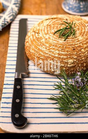 Loaf of home made craft bread on wooden plate with sliced heel and long ...