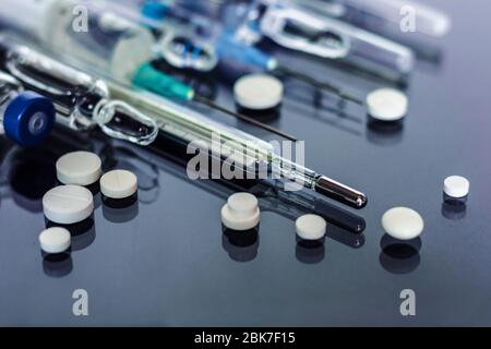 Thermometer, pills, injection vaccine ampoules, syringe for vaccination ...