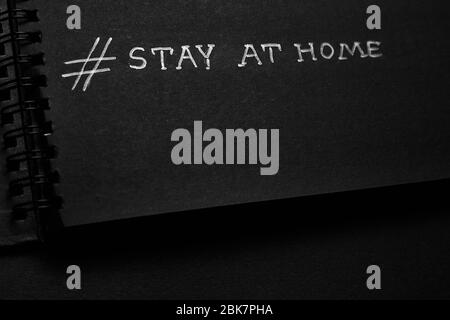Stay at home, text. Headline inscription on black paper background ...