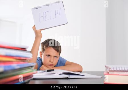 Bored schoolboy tired of doing math homework for school, he is sitting ...