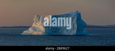 Huge floating iceberg in Disko Bay in the arctic early morning twilight ...