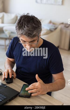 Middle age man using smartphone and credit card at new home Stock Photo ...