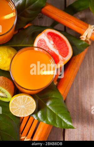 Glasses of tropical exotic multifruit juice on the wooden white tray ...