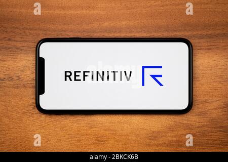 A smartphone showing the Refinitiv logo rests on a yellow background ...