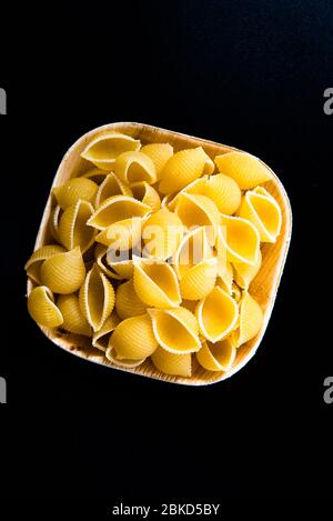 Bowl with uncooked pasta shells on white background Stock Photo - Alamy