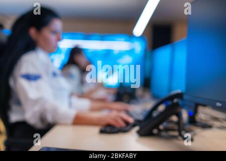 Blurred photo of security guards working on computers while sitting in ...