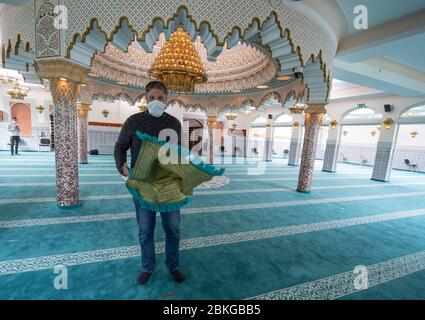 04 May 2020, Hessen, Frankfurt/Main: With his prayer rug a man comes to ...