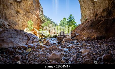 Behind a waterfall from inside a cave at Port Mora on the coastal path ...