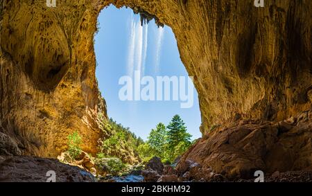 Behind a waterfall from inside a cave at Port Mora on the coastal path ...
