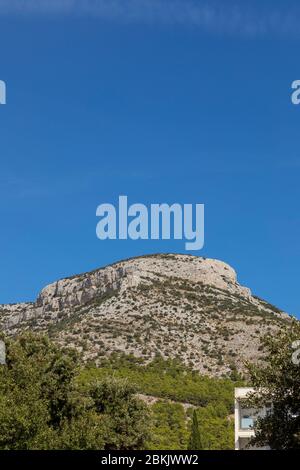 A scenic shot of trees on the coast of a lake surrounded by hills under ...