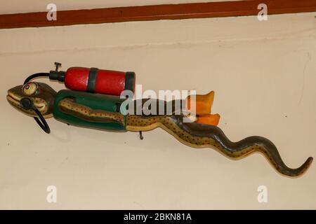 Statue of gecko with diving equipment on the wall of diving center. 3D ...