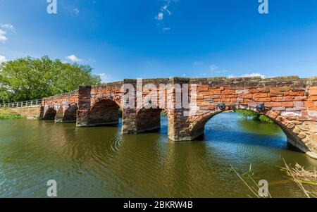 The red sandstone road bridge over the river Avon at Eckington wharf in ...
