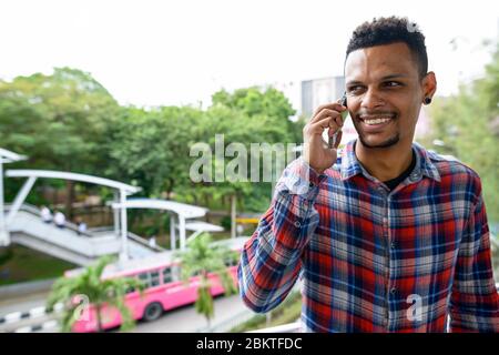 Hipster Black man talking on phone, looking left and having mobile ...