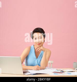 Smiling Vietnamese white collar worker sitting at cafe table and ...