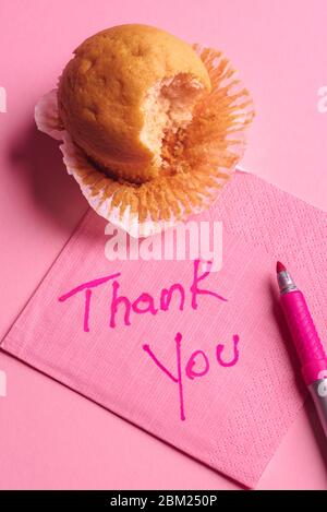 Tasty cupcake with Thank You note and paper cones on pink background ...