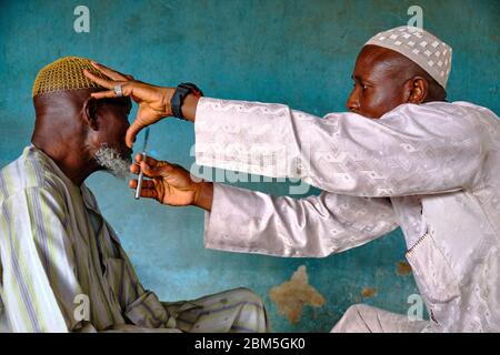 Muslim man shaving the Imam of his mosque with a razor blade Stock ...