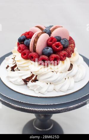 White and pink macaroons with fresh raspberries on black volcano table ...