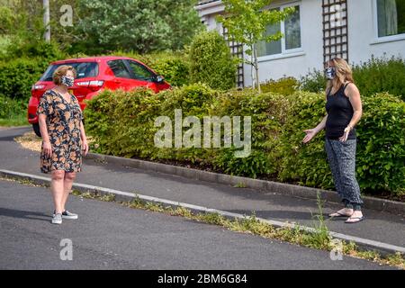 Residents wearing face masks chat each others outside a hotel in ...