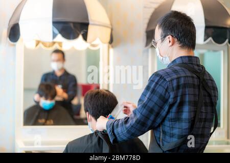 Young man hairdresser in mask cleaning floor in the beauty salon Stock ...