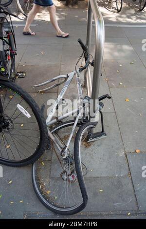 Bicycle with a missing front wheel locked up Stock Photo - Alamy