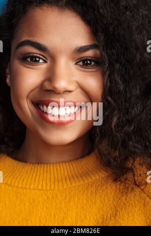 Optimistic young African American female model smiling looking at ...
