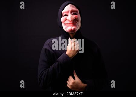 Portrait of young man with hoodie and horror mask Stock Photo - Alamy
