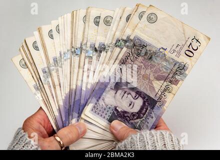 Wad of twenty pound notes cash in hands Stock Photo - Alamy