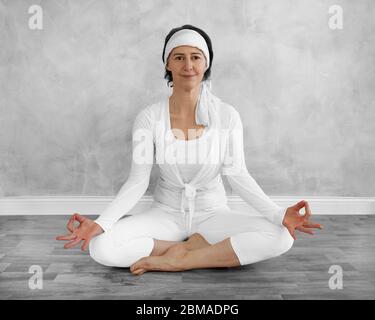 A young woman practices yoga at home, stretching gracefully on a mat ...