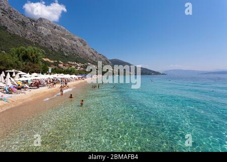 Corfu, Greece: People at the beach swimming and sunbathing Stock Photo ...