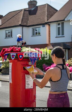 Person seen posting a letter in an old style, red-painted Royal Mail ...