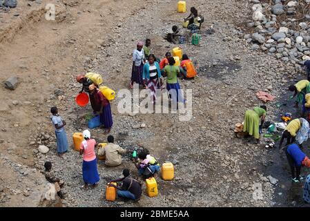 Group of people fetching water from a free flowing water source Stock ...