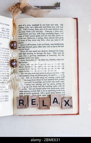 The word 'relax' spelled out in colourful plastic letters, on green ...