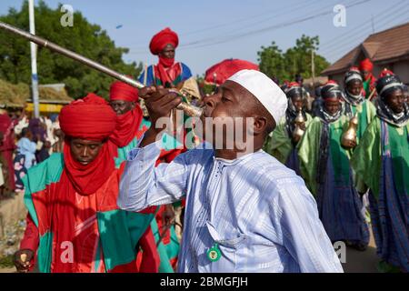 Musician playing traditional Nigerian trumpet during the celebration of ...