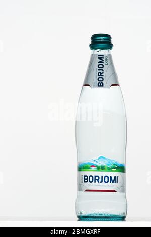 Borjomi glass bottle, Georgian mineral water on turquoise wood background. Healthy beverage that ...