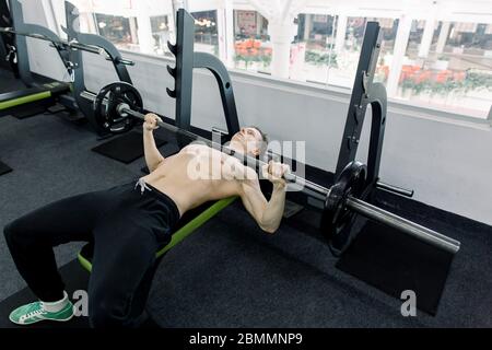 Portrait of sportive man pumping the press with fitness ball on rug ...