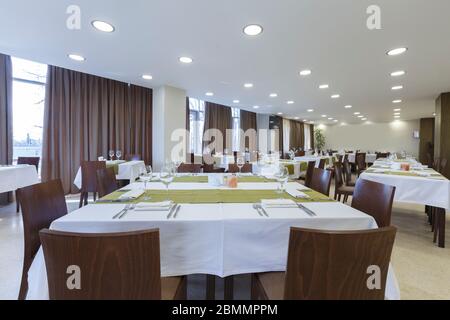 A restaurant empty room decor with tables and chairs in white and black ...