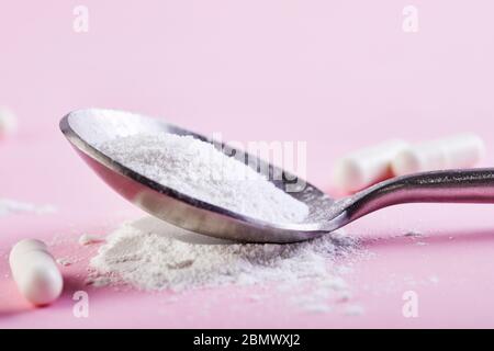 A pink protein powder with spoon in blue background Stock Photo - Alamy