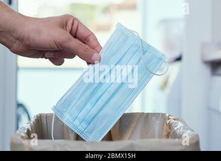 Man throwing used surgical mask into recycling bin. Waste disposal ...