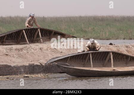 Boatmen fix their traditional boats (Mashoof), using bitumen to seal ...