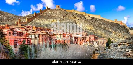 a scenic view of the medieval town Albarracin with hills and city walls ...