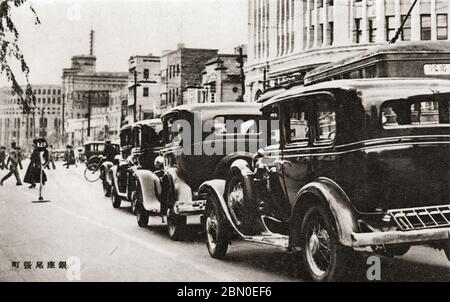 [ 1930s Japan - Ginza, Tokyo ] — Cars pass by stores on Tokyo's Ginza ...