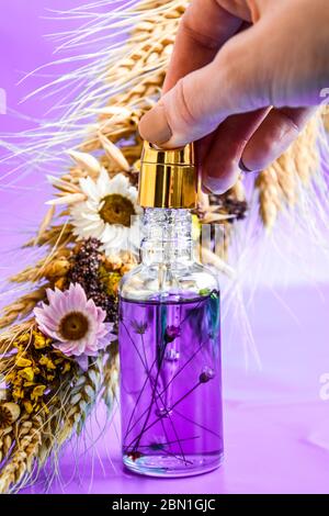 Bottles of essential oils, flowers, spa stones and text NATURAL ...