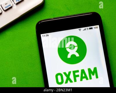 In this photo illustration Oxfam logo is seen displayed on a smartphone ...