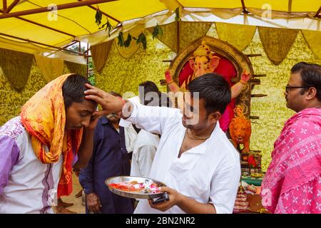 Tika or tilaka mark on the forehead of a currency dealer in India ...