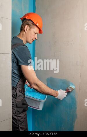 Blue floor waterproofing. Floor waterproofing in bathroom. Worker ...